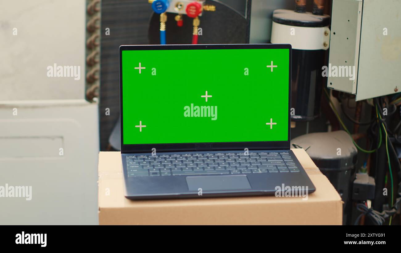 Green screen laptop in front of damaged outside HVAC system. Mock up ...