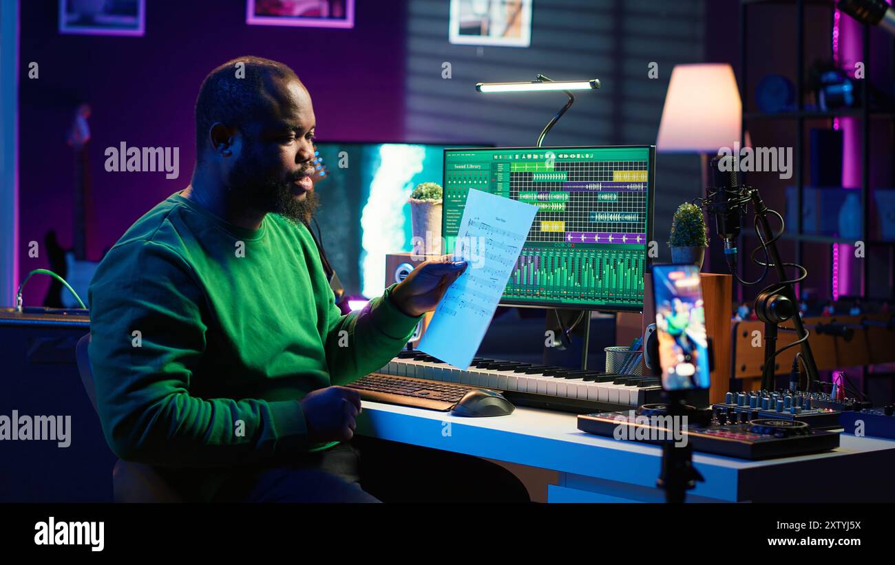 Artist pointing at musical sheet notation to explain notes on piano ...
