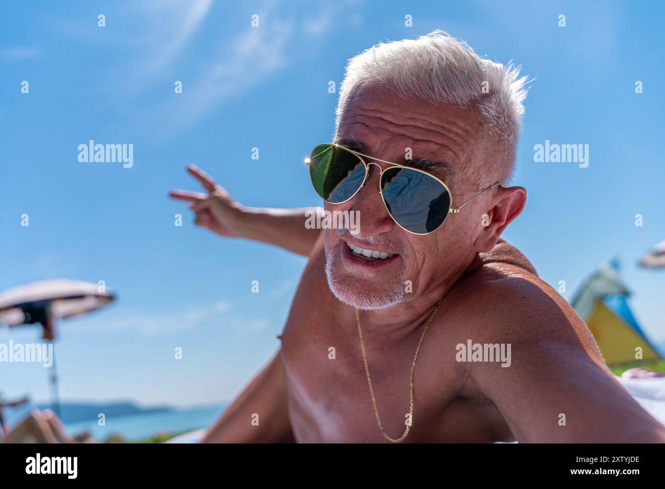 a middle aged man with white hair and goatee happy and smiling taking a ...