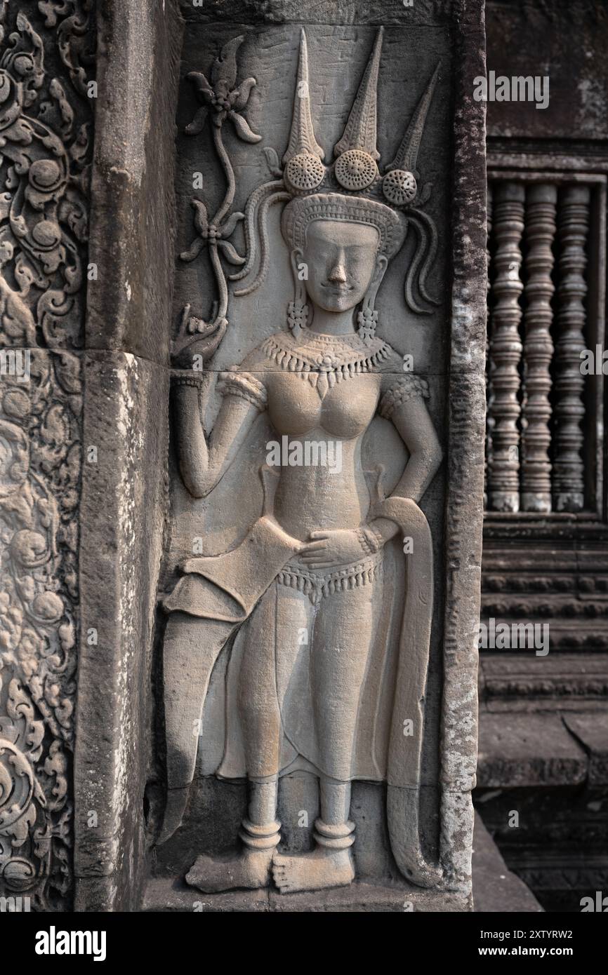 Carving of a beautiful apsara in traditional dress decorating the walls ...