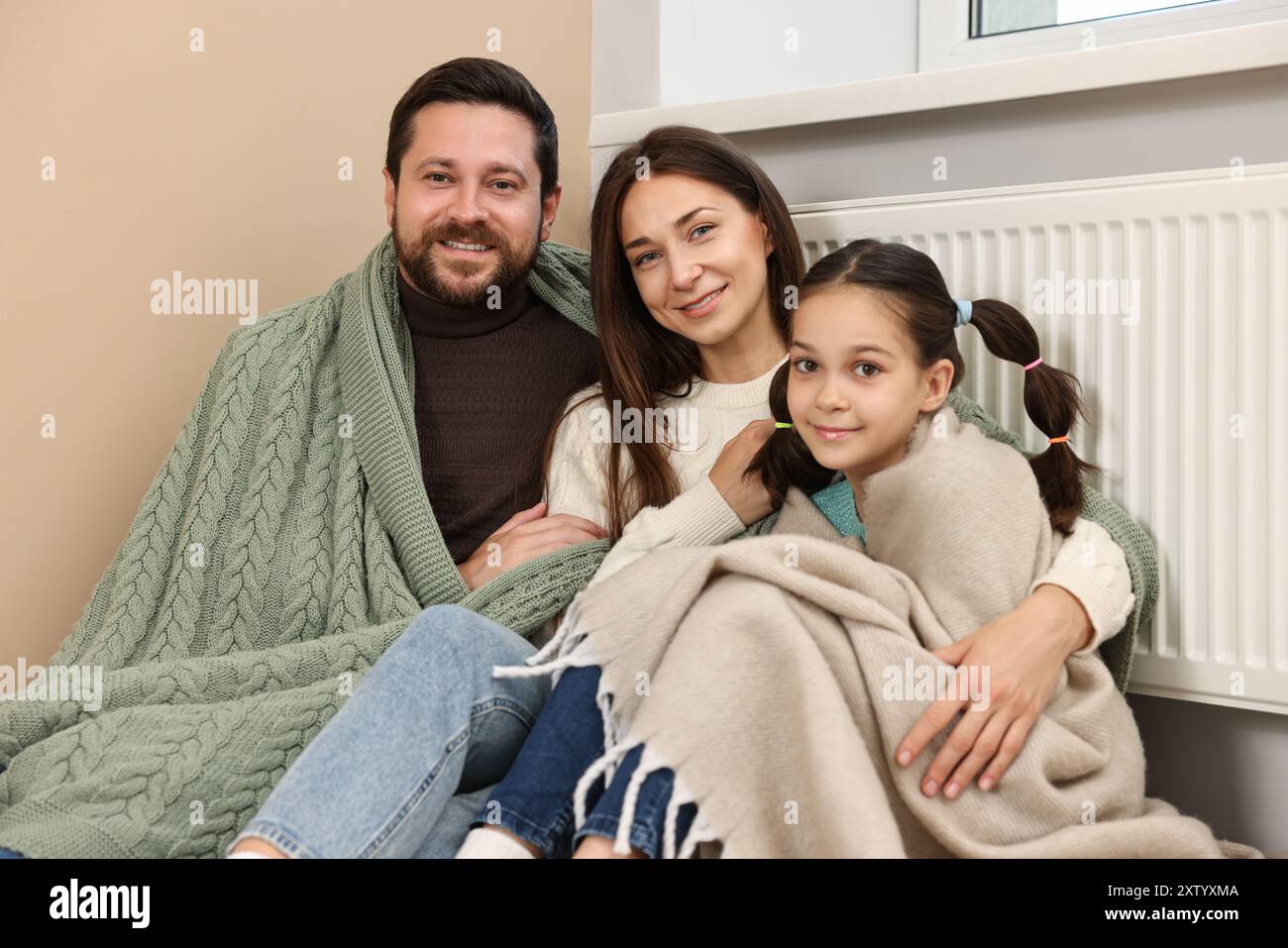 Happy family near heating radiator at home Stock Photo - Alamy