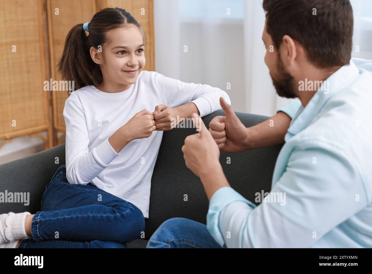 Man and his daughter using sign language for communication at home ...