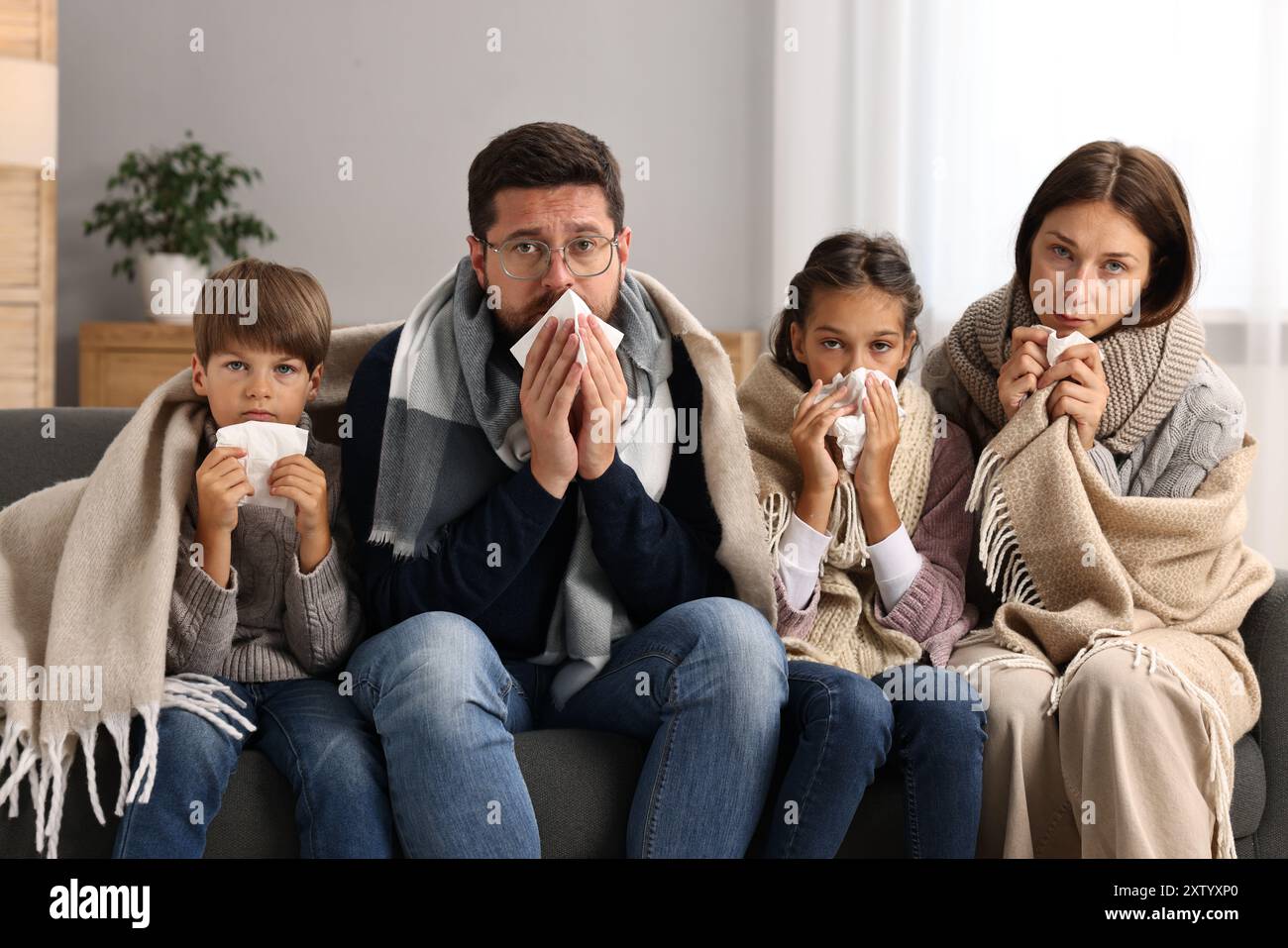Cold symptom. Family suffering from fever on sofa at home Stock Photo ...
