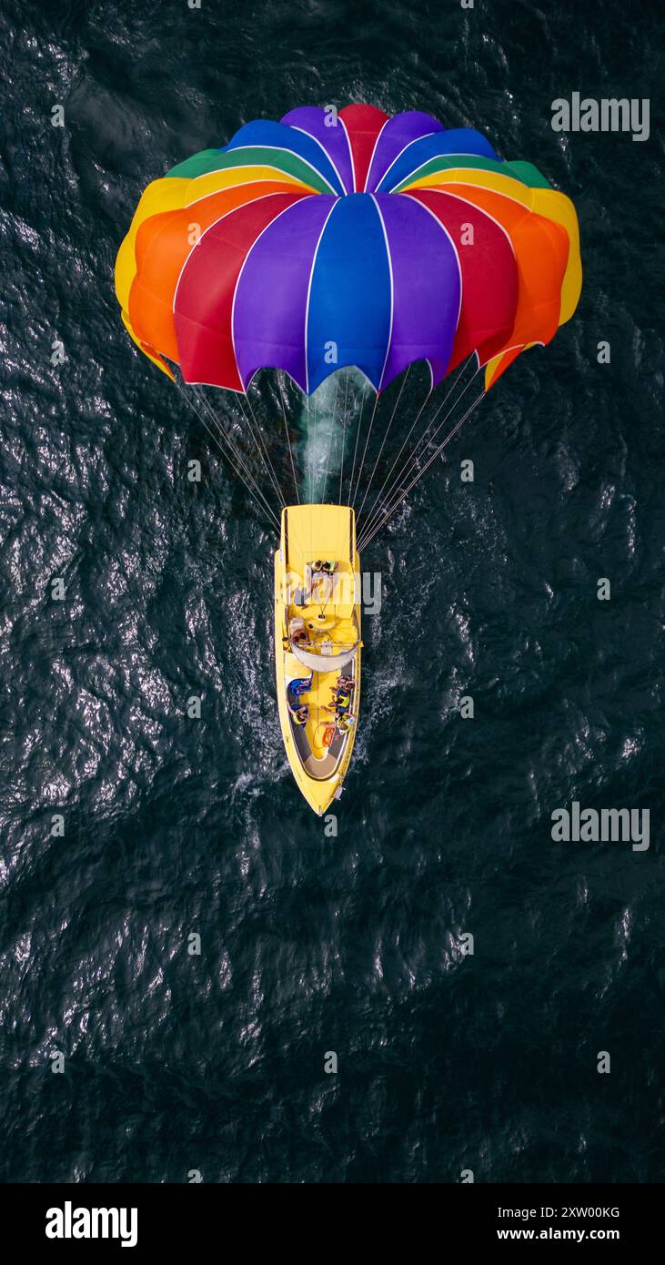 Drone video of a colorful parasail soaring over the open ocean, towed ...