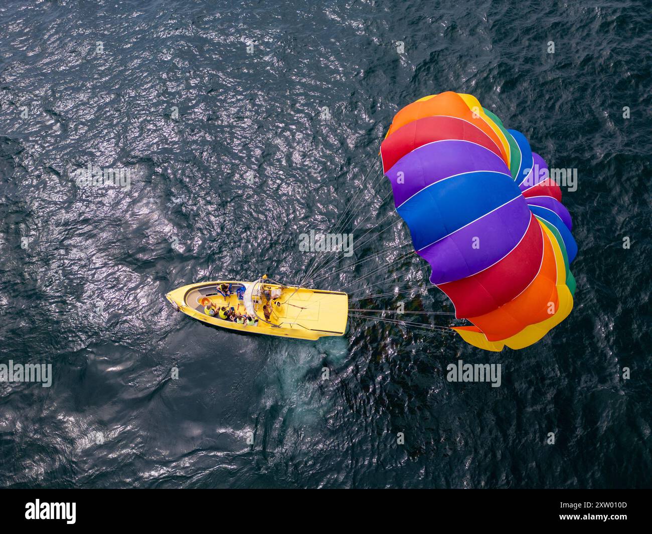 Drone video of a colorful parasail soaring over the open ocean, towed ...