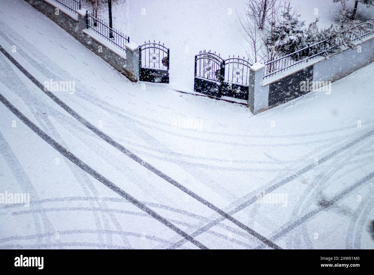 Snowy road with tire tracks leading to a gate, symbolizing life's paths ...