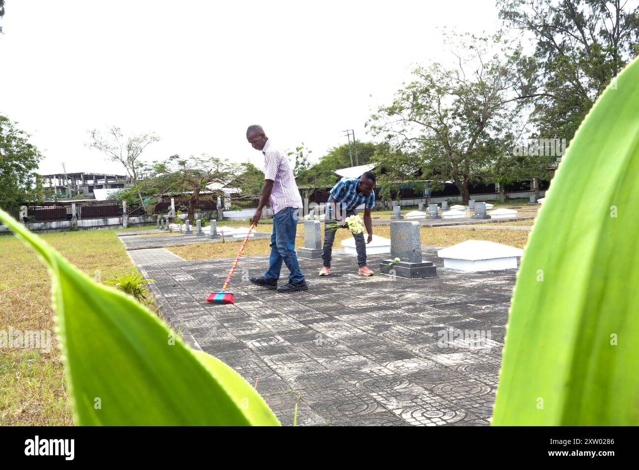Dar Es Salaam, Tanzania. 12th Aug, 2024. Cemetery keepers Msafiri (R ...