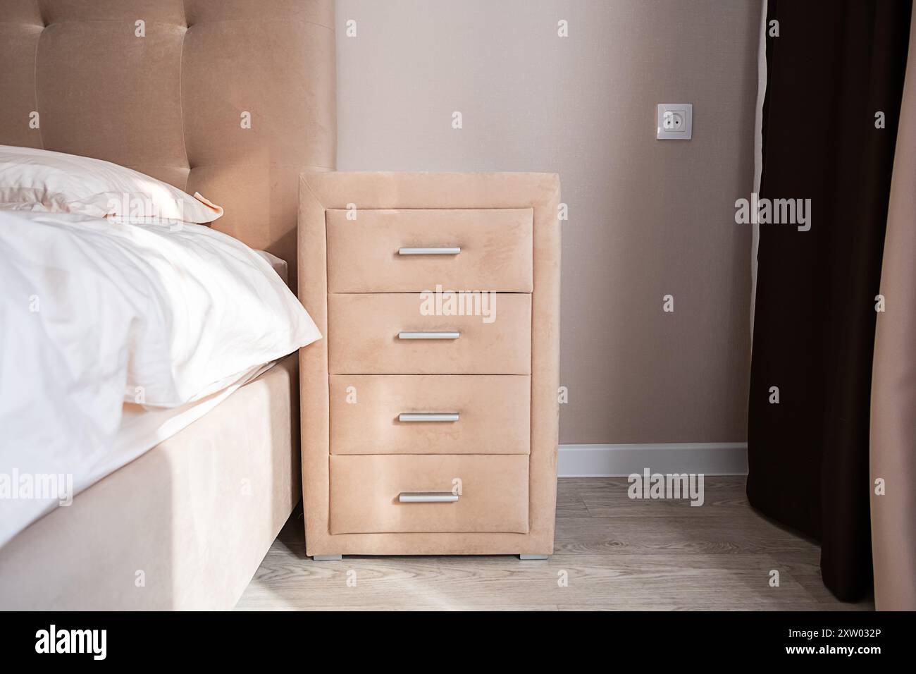 Beige dresser with four drawers near the bed. Well organized bedroom in ...