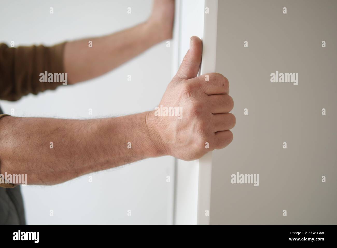 A man is currently holding a door frame while he is engaged in ...