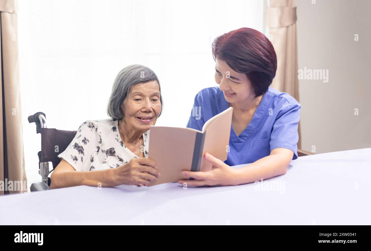 Elderly woman reading aloud a book for dementia therapy with caregiver ...