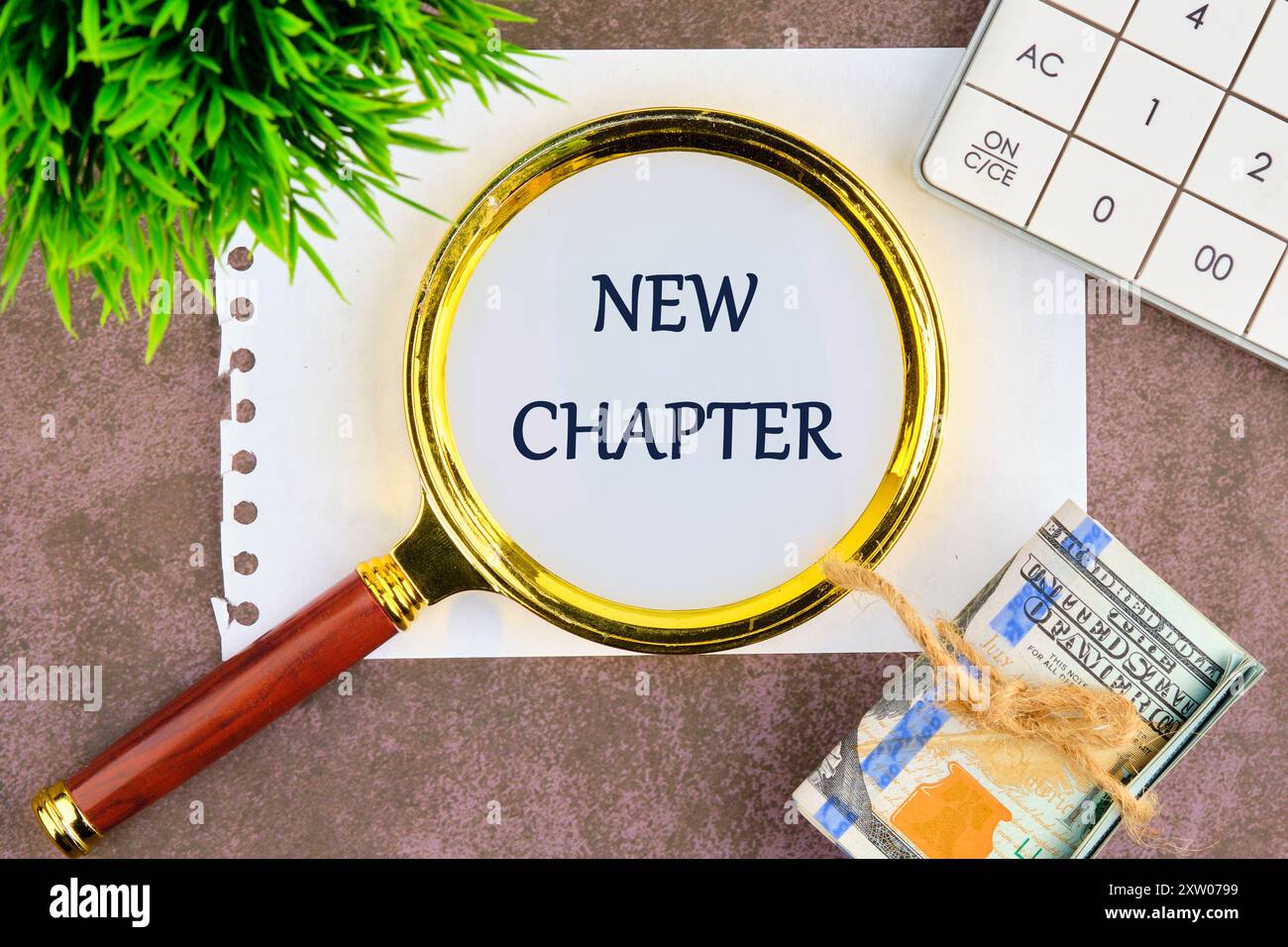 Text sign showing the NEW CHAPTER through a magnifying glass on a piece ...