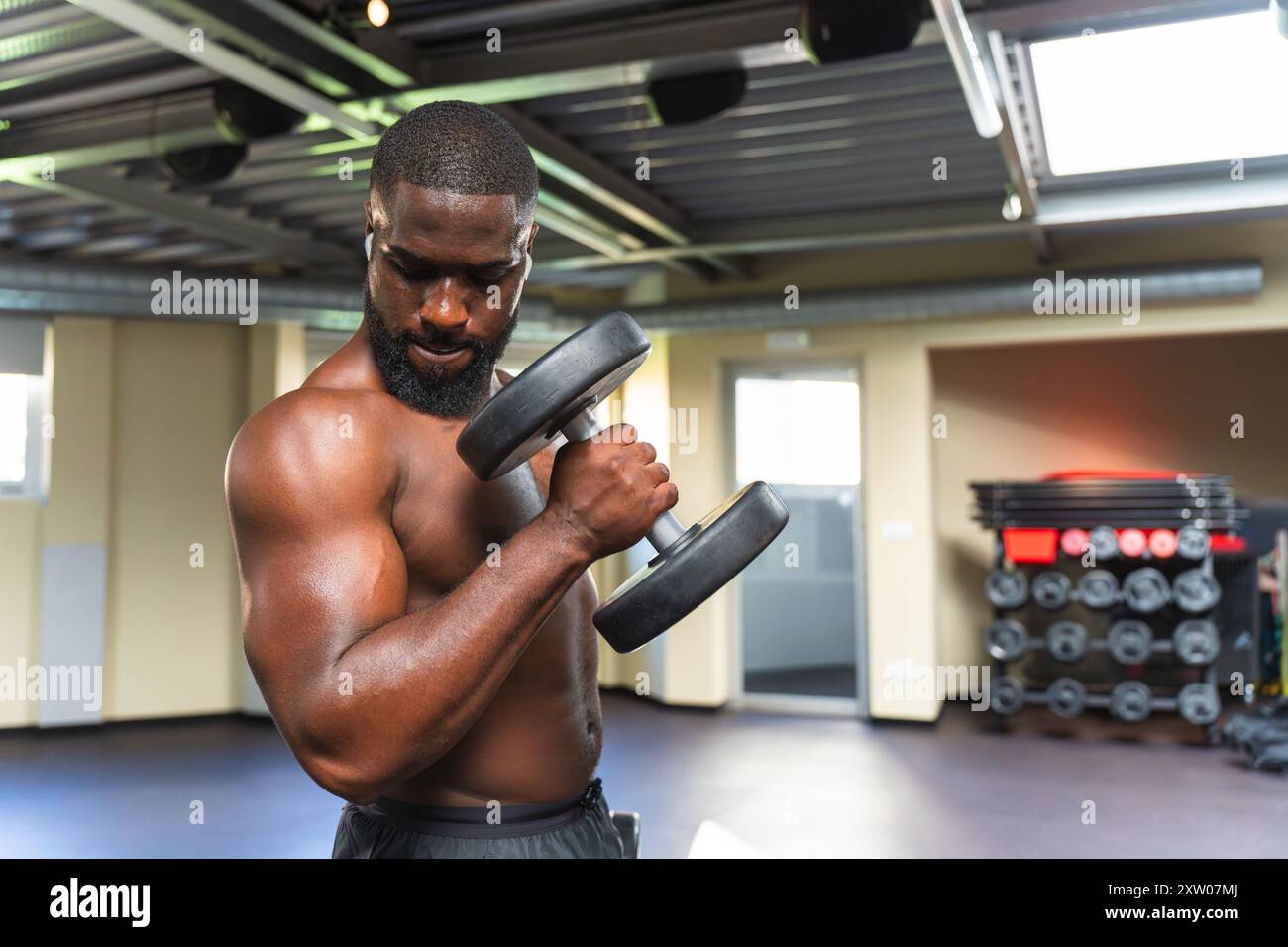 Black man with muscular body working upper body with dumbbells Stock ...