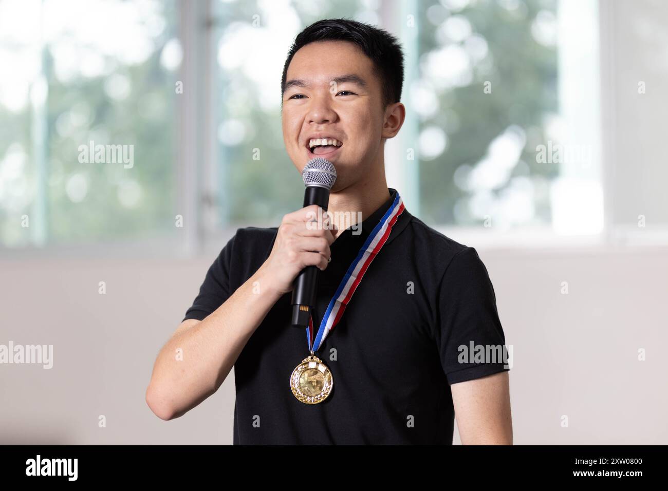 A young teenage boy student is giving an interview victory speech with ...