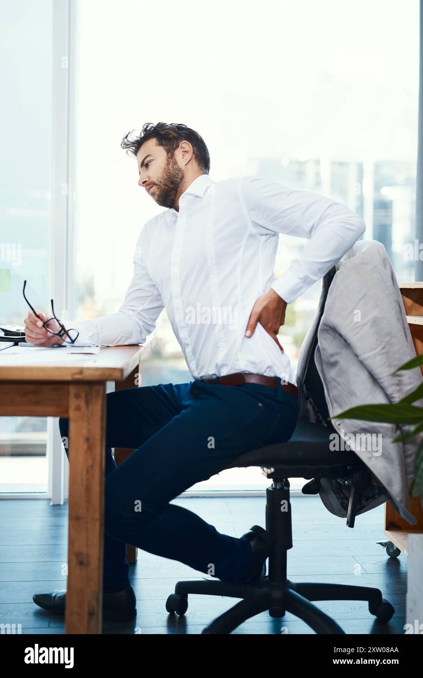Frustrated businessman, back pain and desk with injury from accident ...