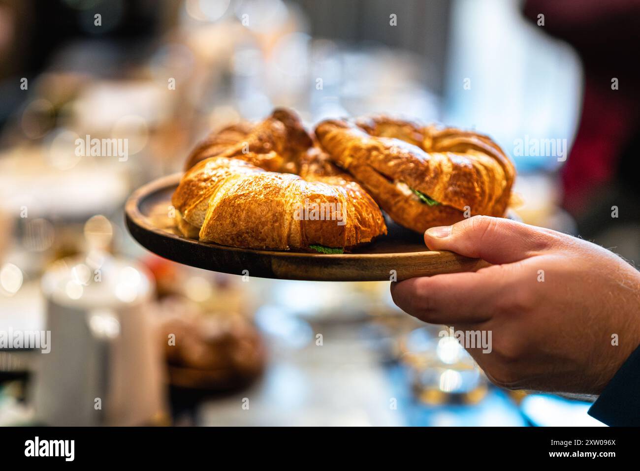 Breakfast in the restaurant. Hand serving croissants Stock Photo - Alamy