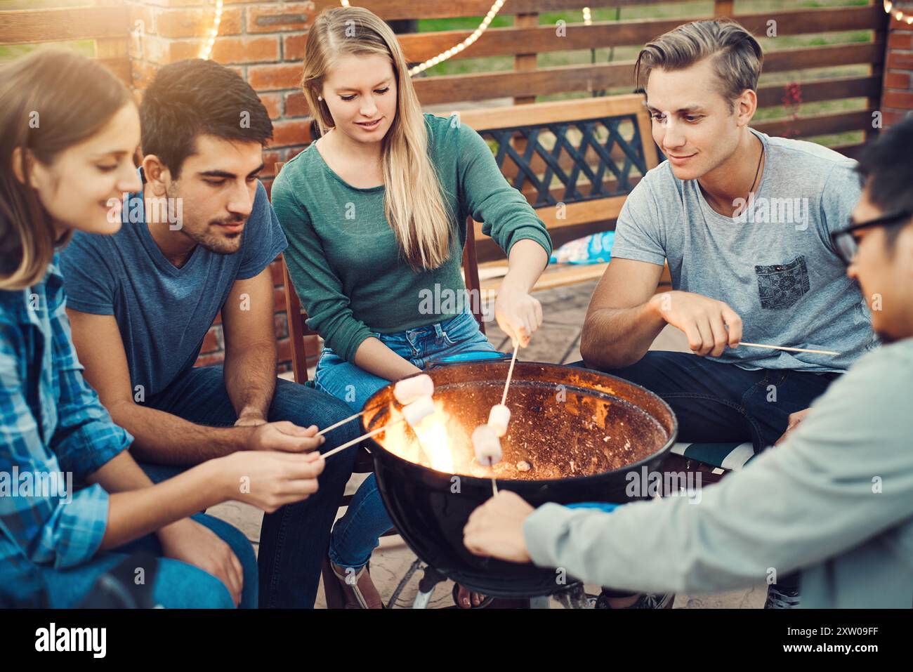 Fire, happy and friends roasting marshmallows in backyard for social ...