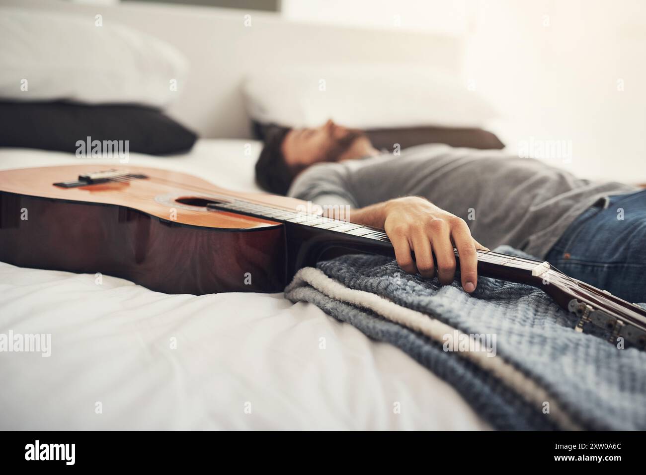 Tired, sleeping and man with guitar on bed from performance, music ...