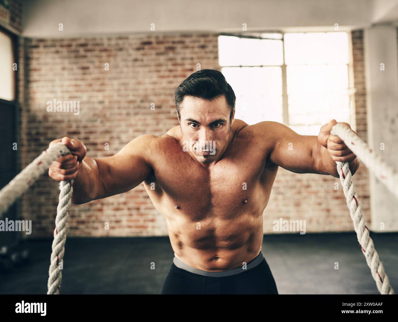 Man, bodybuilder and rope for training at gym for bodybuilding with ...