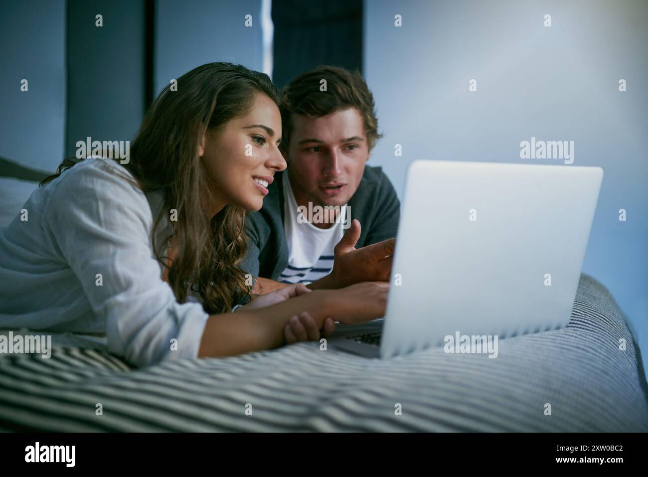 Happy, couple and night with laptop in bedroom for streaming ...