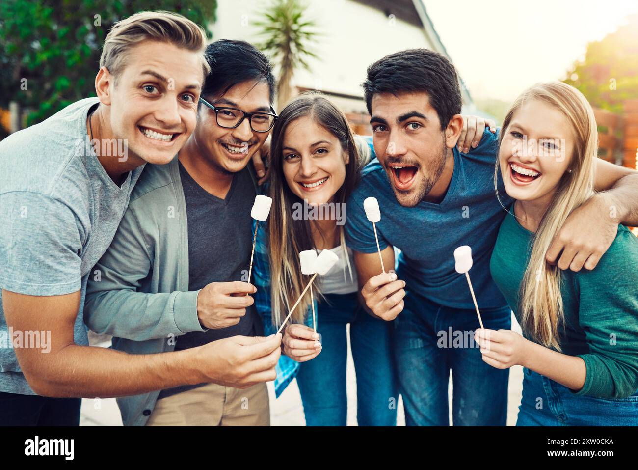 Happy, portrait and people roasting marshmallows in backyard for social ...