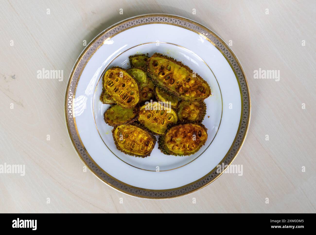 Spiny gourd (Momordica dioica) fry or kakrol bhaja in a white plate on ...