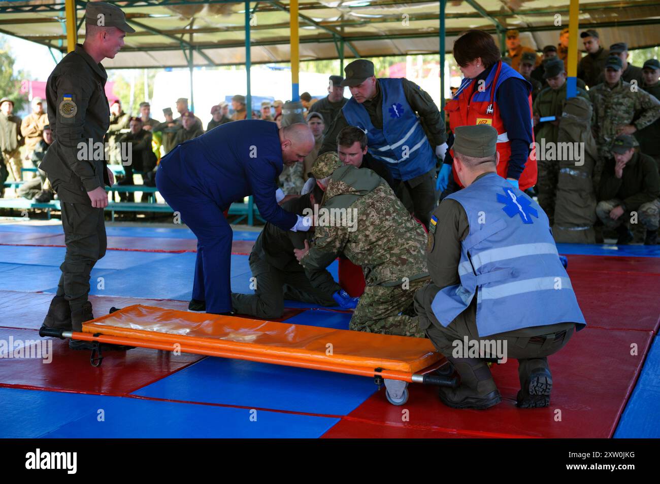 Army combative. Paramedics examining knocked out soldier fighter in a ...