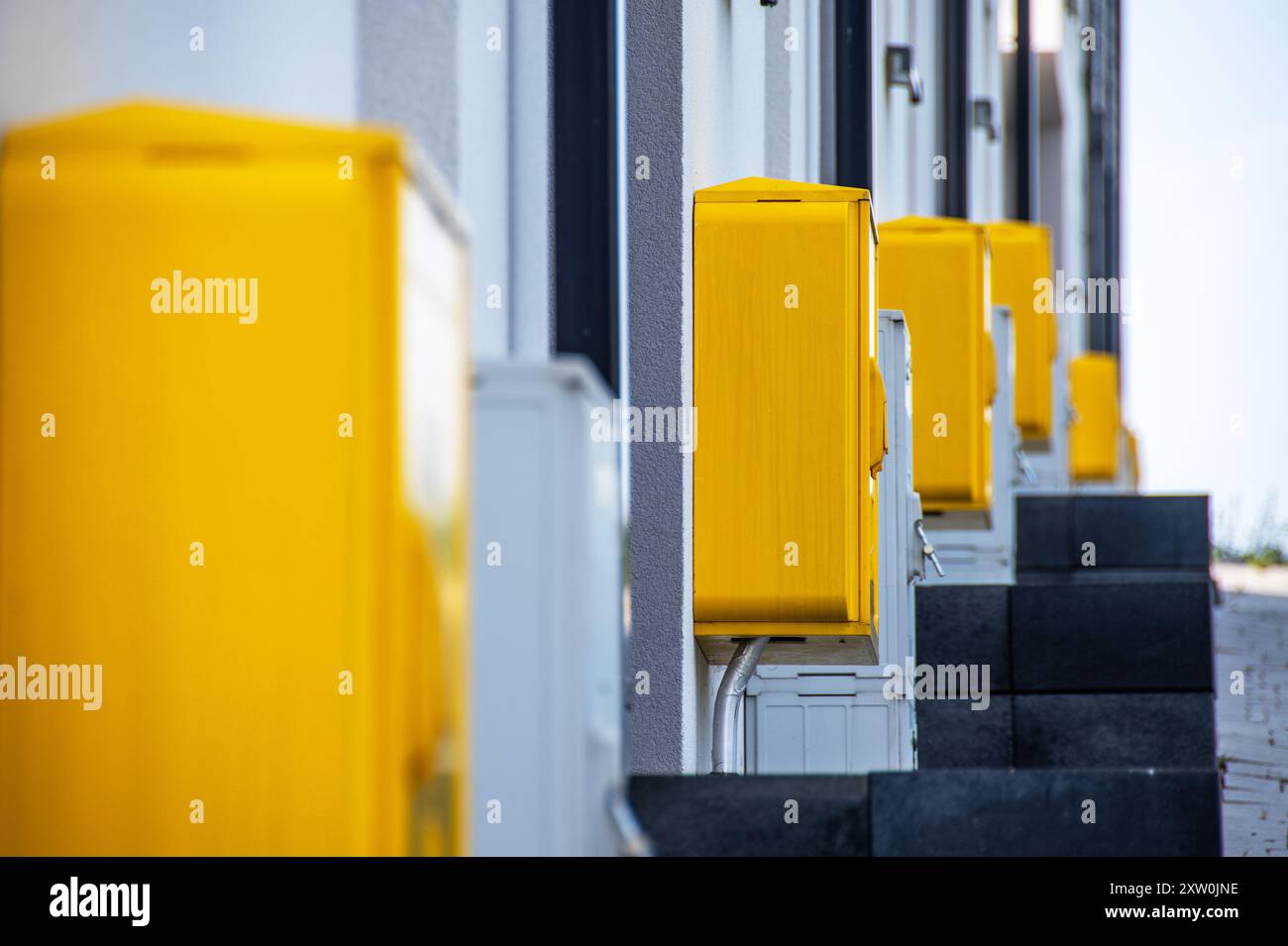 Yellow gas meter boxes arranged neatly on the exterior of a residential ...