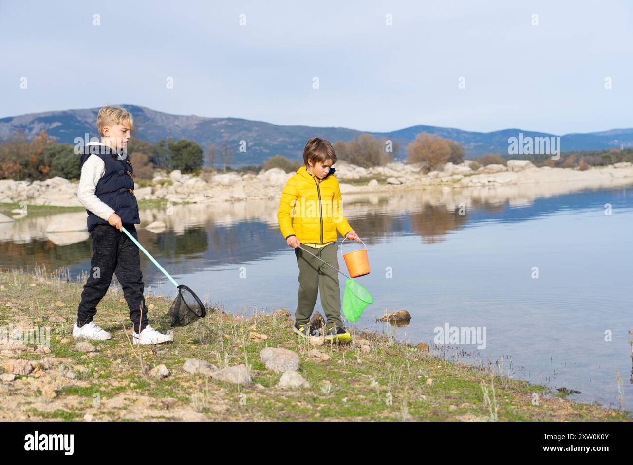 Two Caucasian children playing fishing on the shore of a lake Stock ...