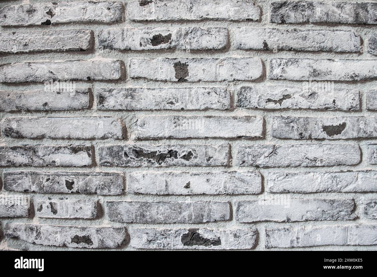 A close-up view of a weathered grey brick wall, showcasing unique ...