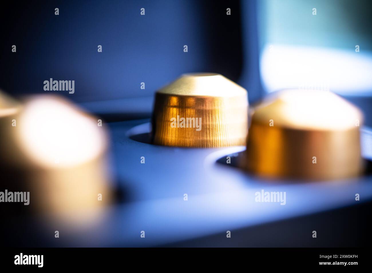 A close-up view of elegant gold espresso capsules arranged in a sleek ...