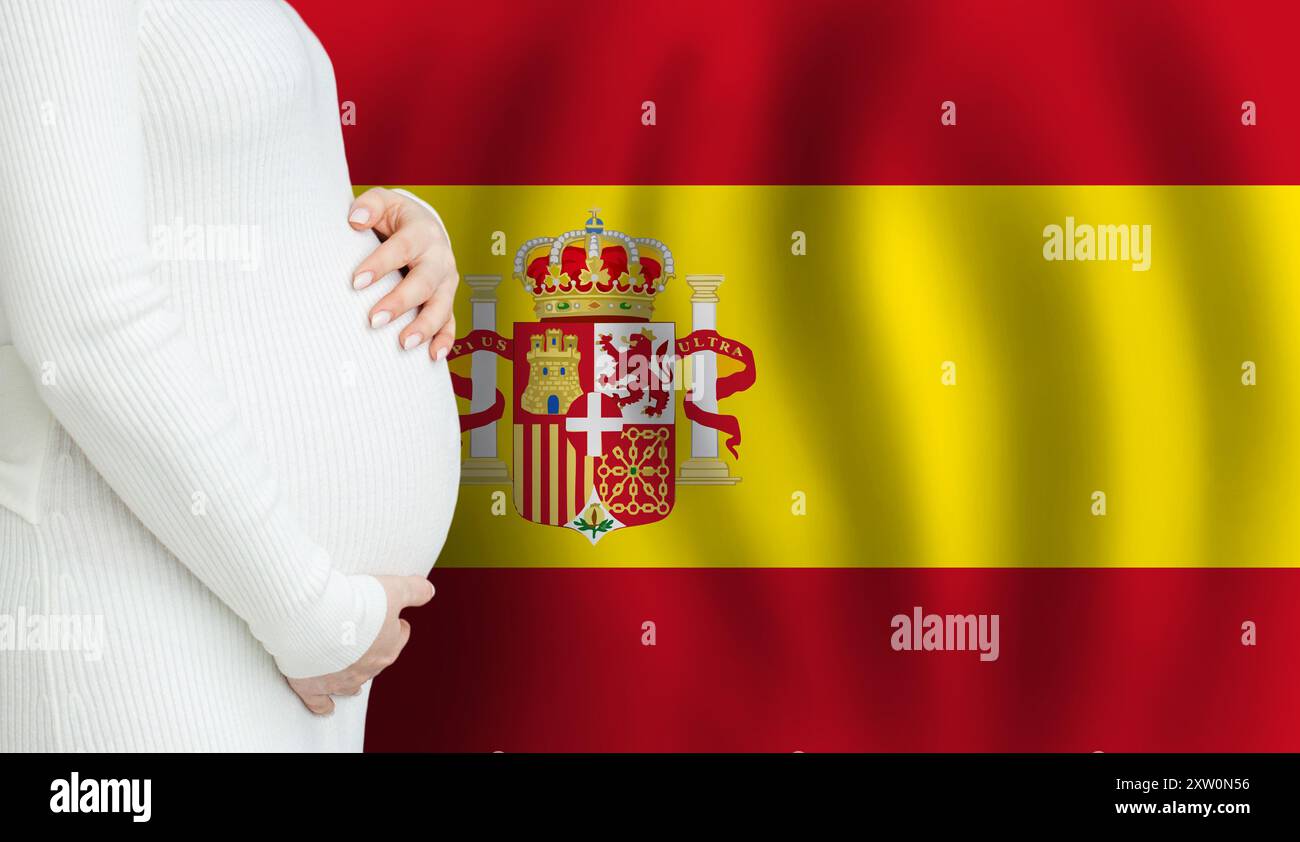 Pregnant woman belly against Spanish flag background. Demographics and ...