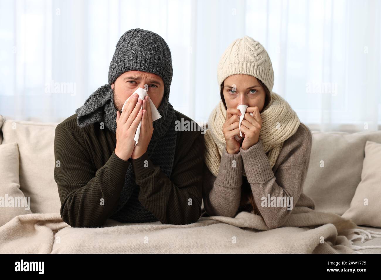 Cold symptom. Couple suffering from fever on sofa at home Stock Photo ...