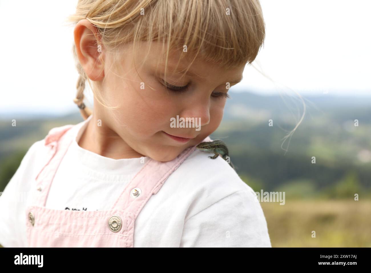 Cute little girl with lizard on shoulder outdoors. Enjoying beautiful ...