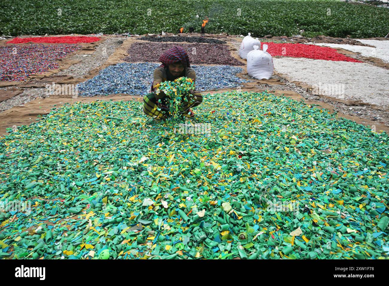 Bangladesh workers dry recycled plastic waste in the sun that will be ...