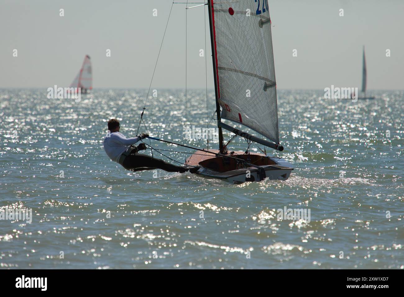 A sailor leans out at the Sailing Dinghy racing event at Hythe,Kent,UK ...