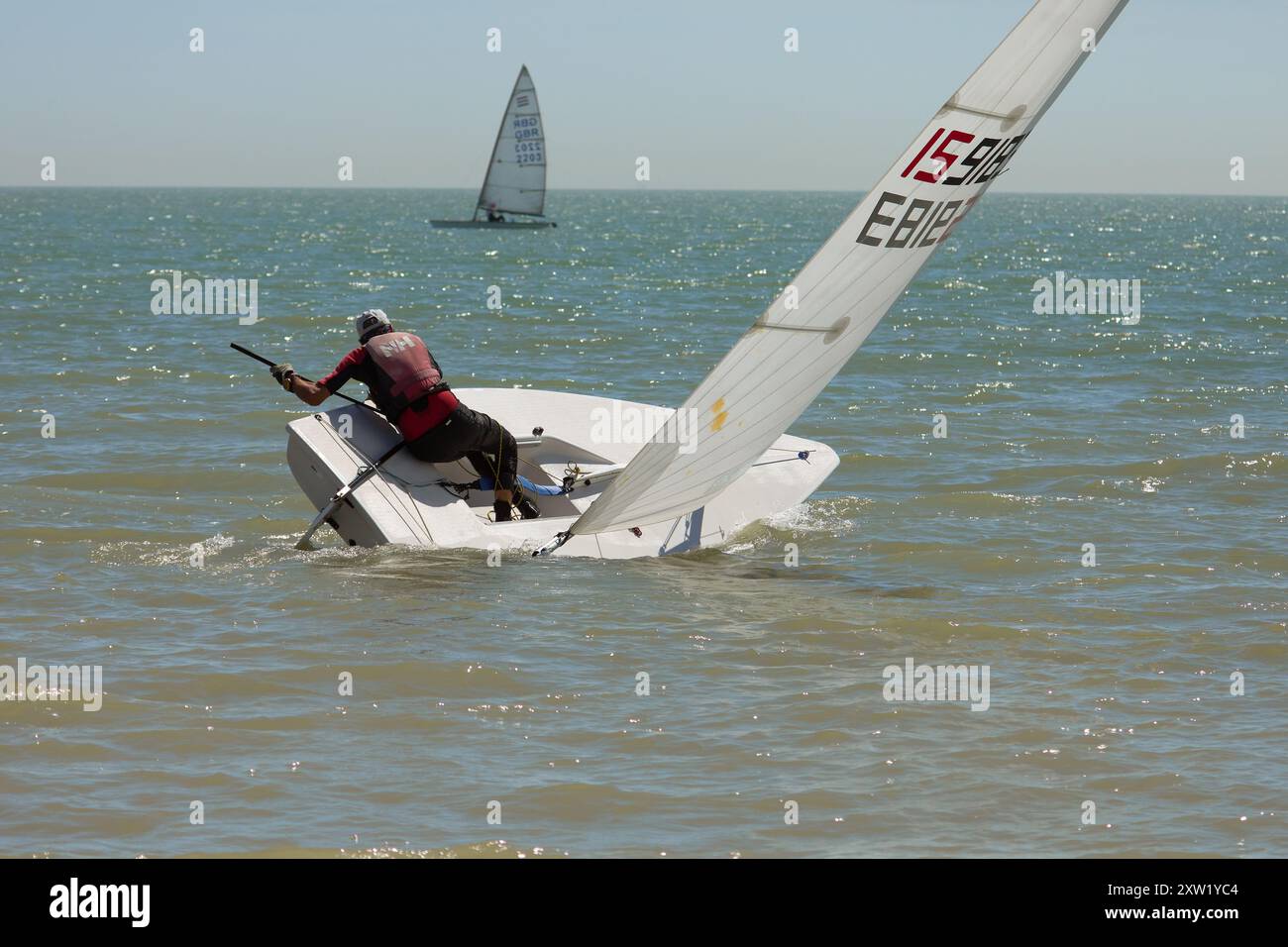 A local sailing enthusiast capsizes during a dinghy race at Hythe, Kent ...