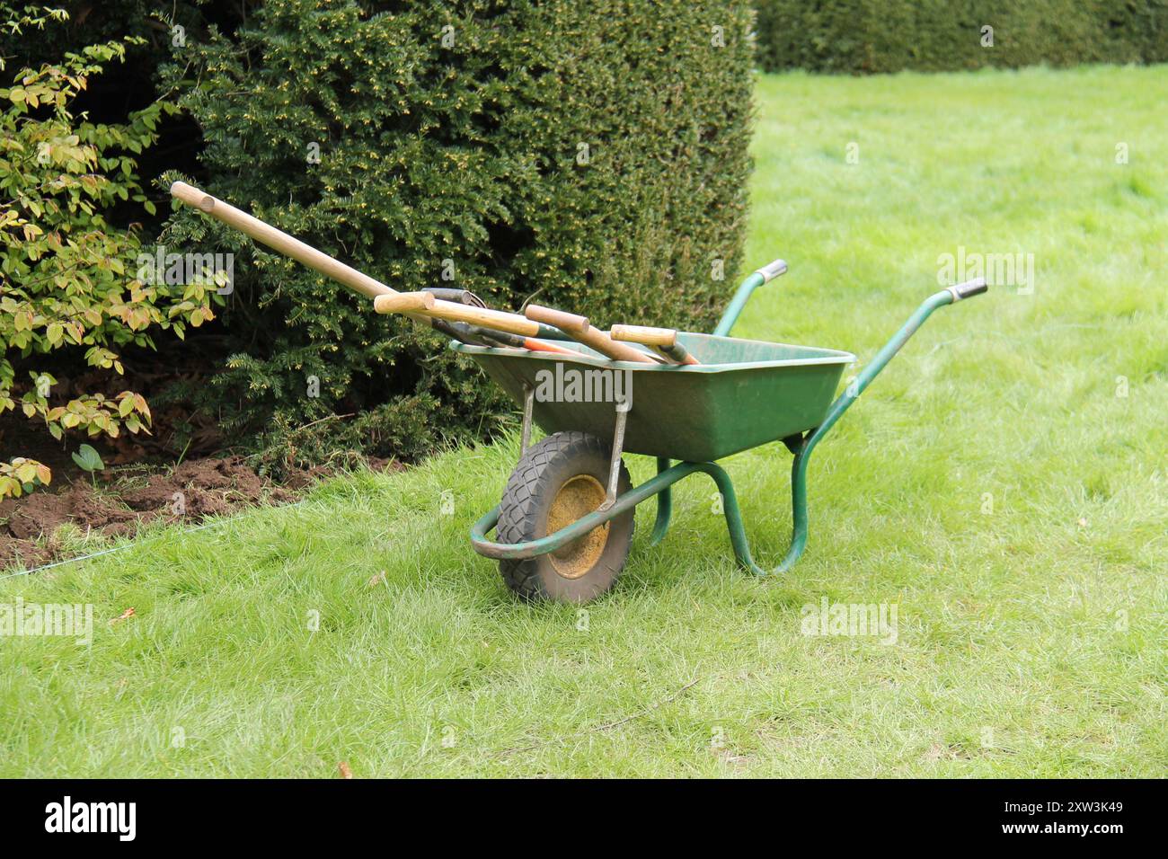 A Gardeners Wheelbarrow with a Collection of Tools Stock Photo - Alamy