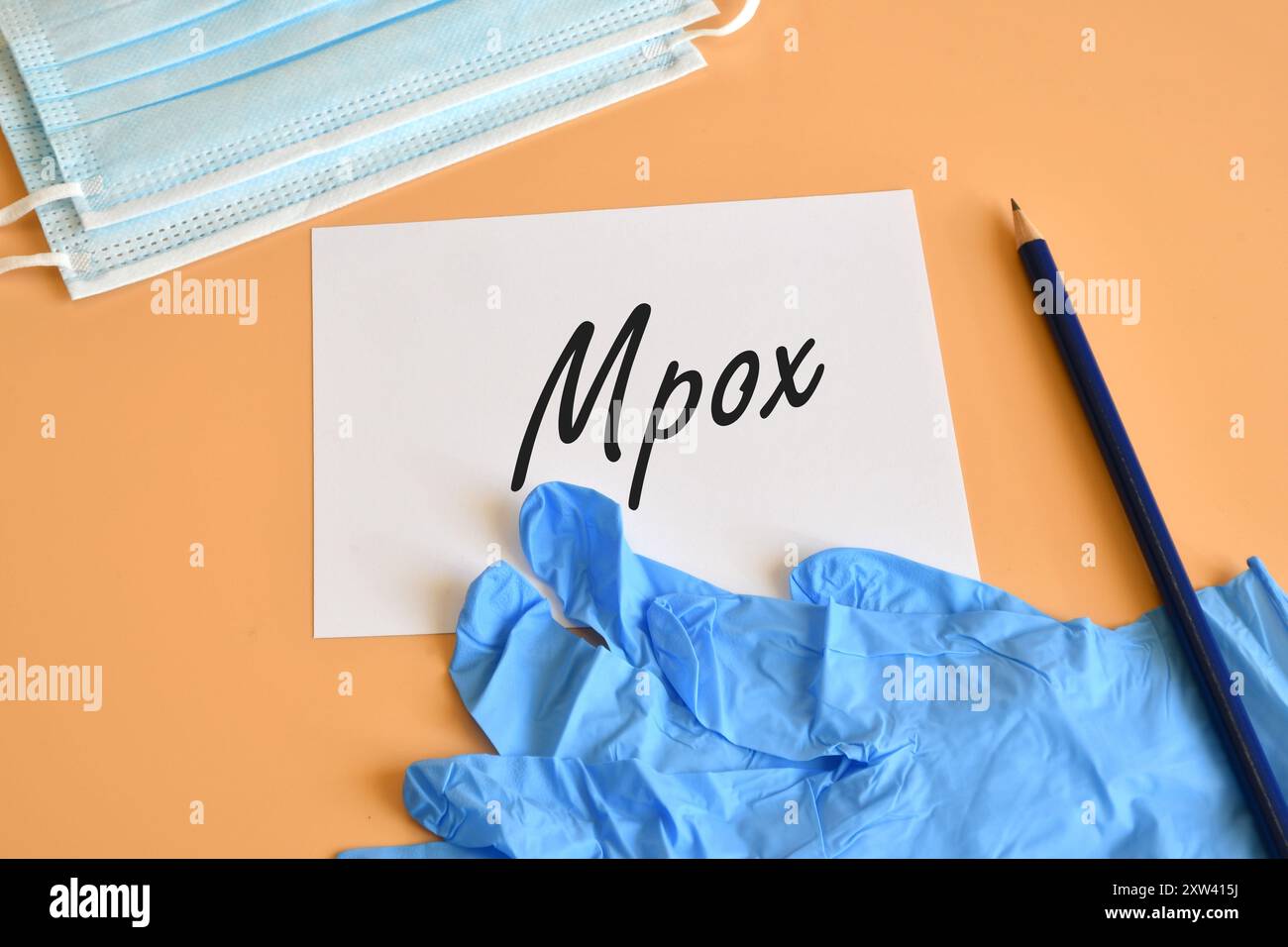 Protection masks and blue surgical gloves with white paper and text ...