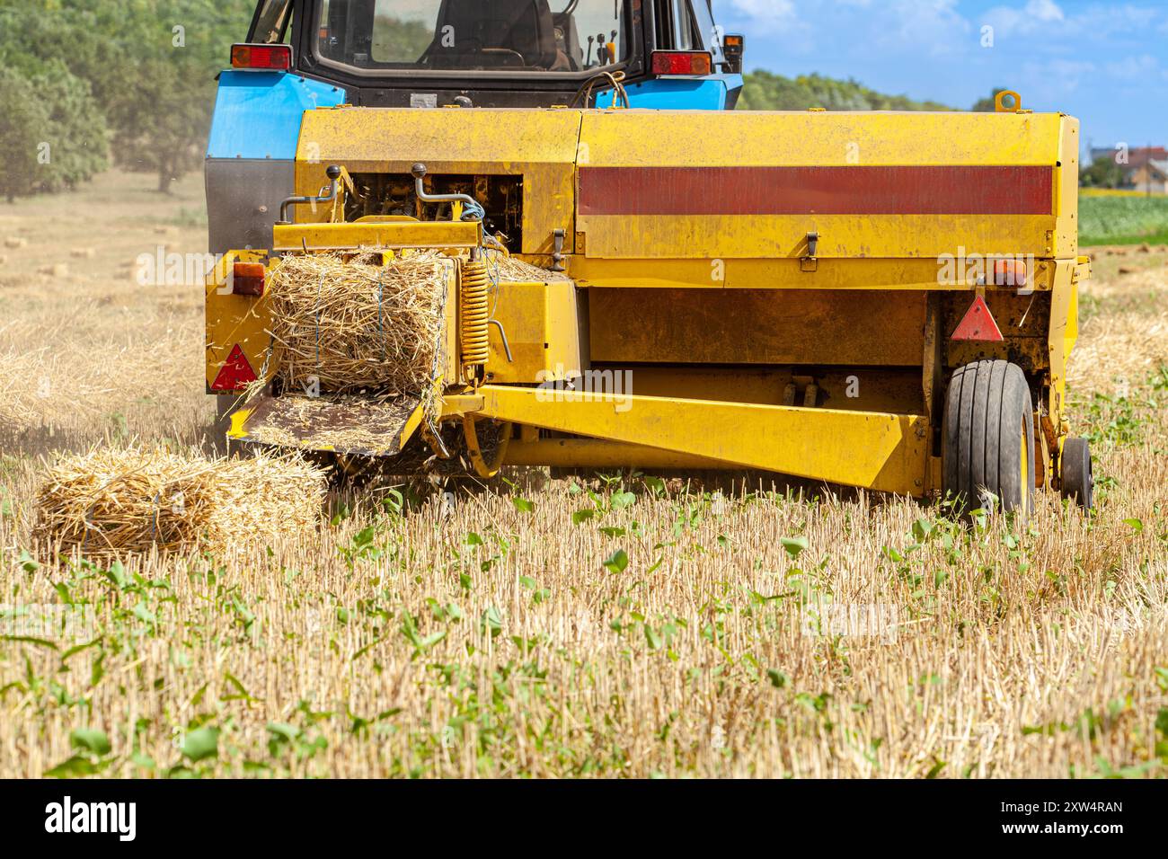 The photo shows the moment of making a straw bale in a field in ...