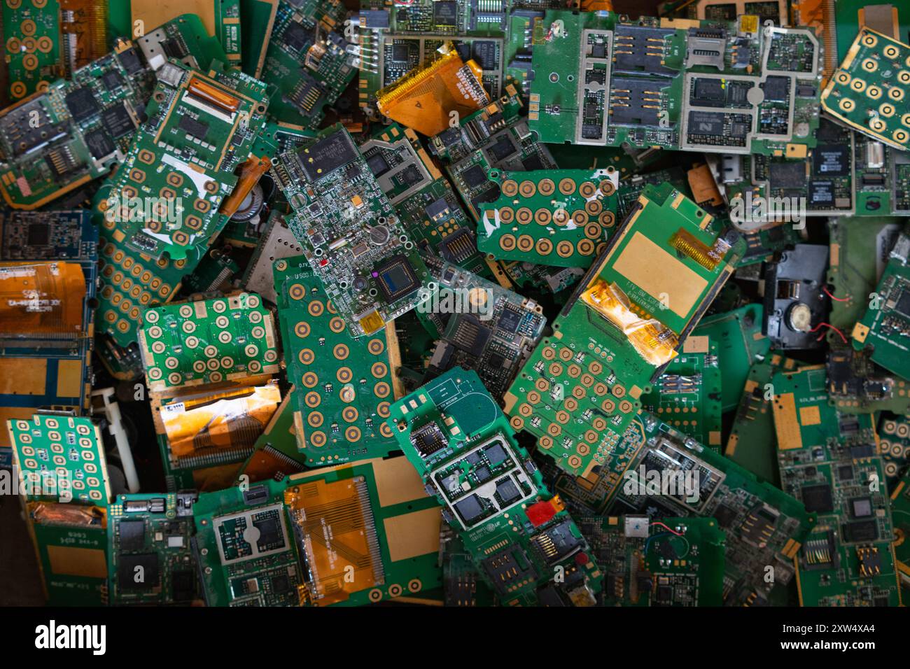 pile of electronic waste on factory floor is circuit board of mobile ...