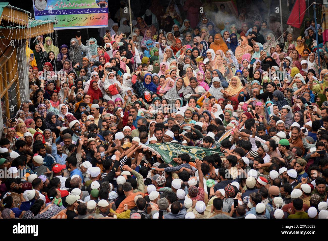 Srinagar, India. 17th Aug, 2024. Devotees carrying a cloth known as a chadar and flowers are ...