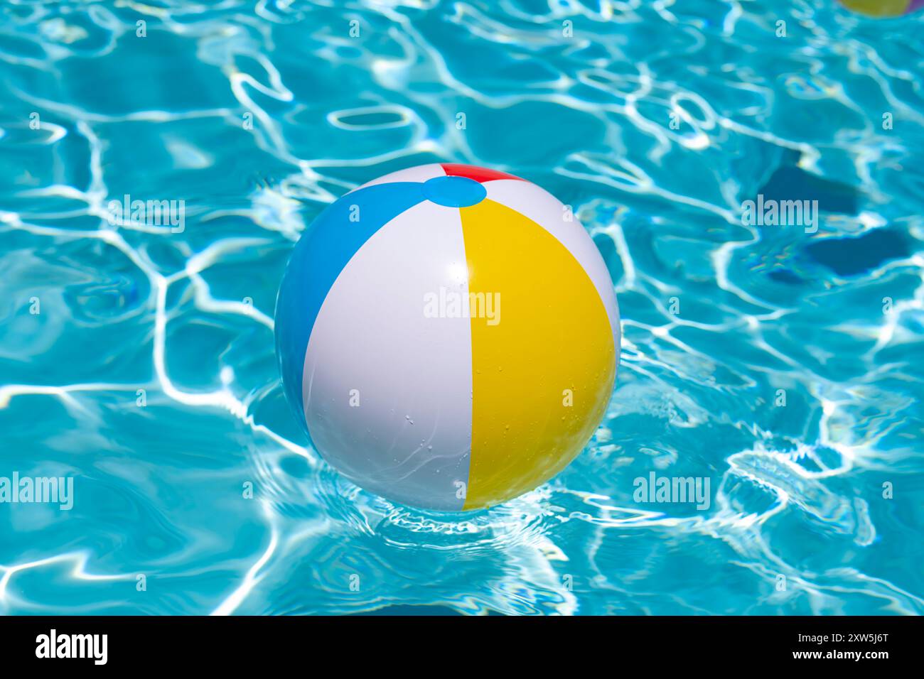 Beach ball. Colorful inflatable ball floating in swimming pool. Summer ...