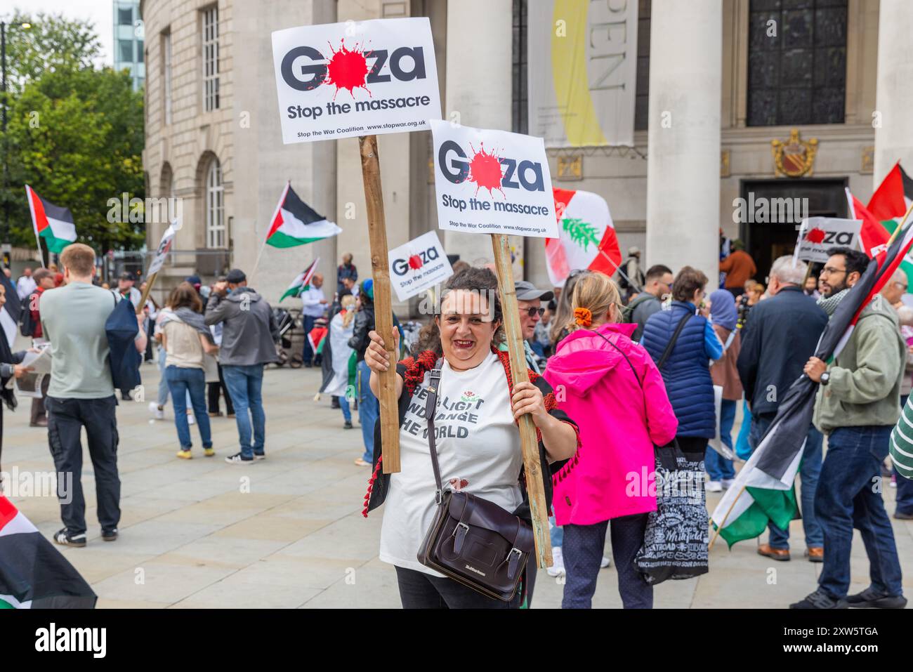 Manchester, UK. 17 AUG, 2024. Lady holds two "Gaza, stop the massacre ...