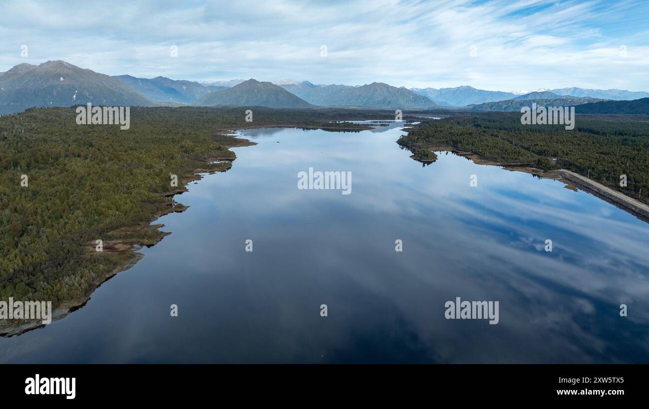 Remote Kapitea Reservoir reflections surrounded by mountain ranges ...