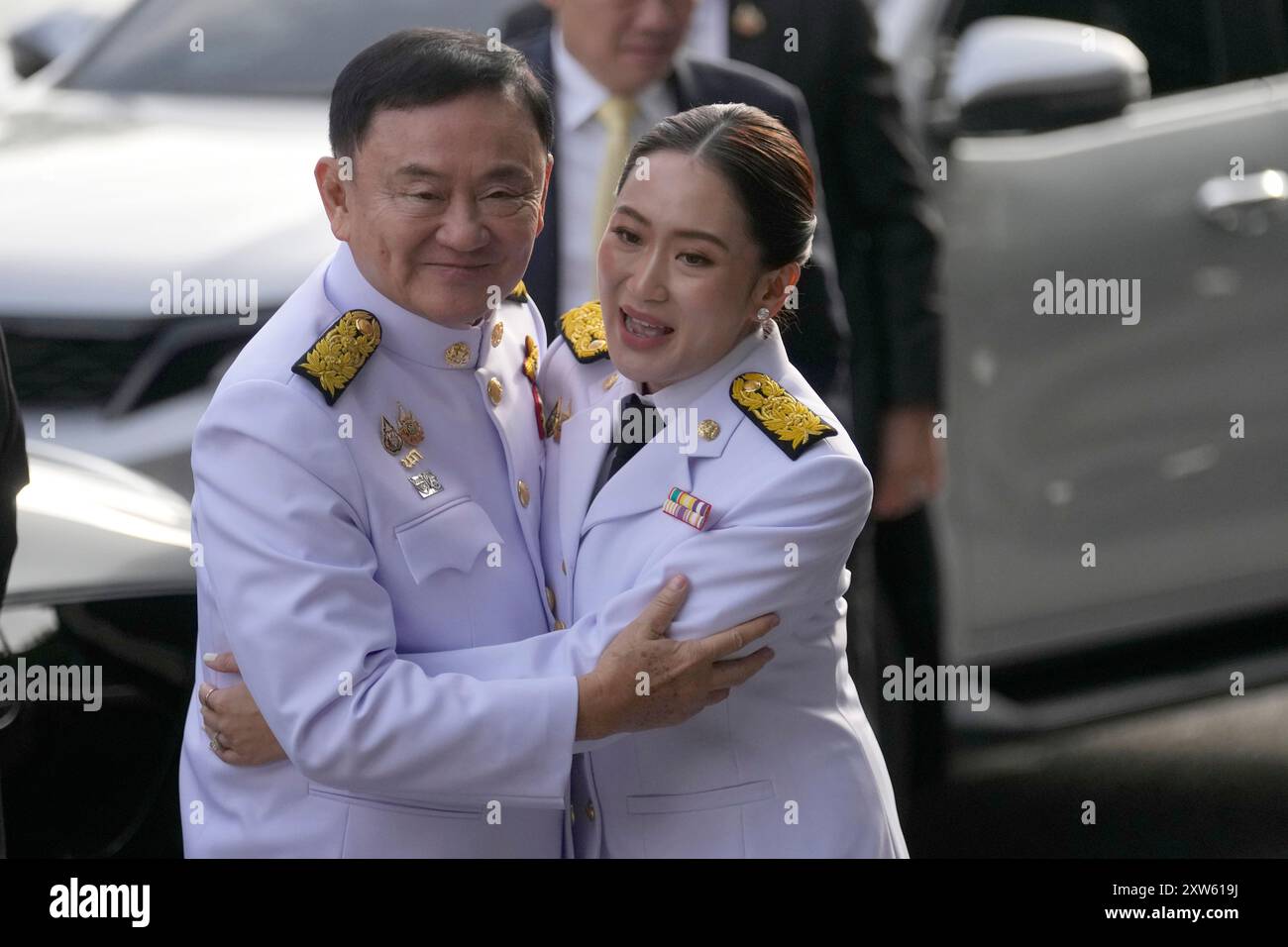 Thailand's former Prime Minister Thaksin Shinawatra, left, hugs his ...