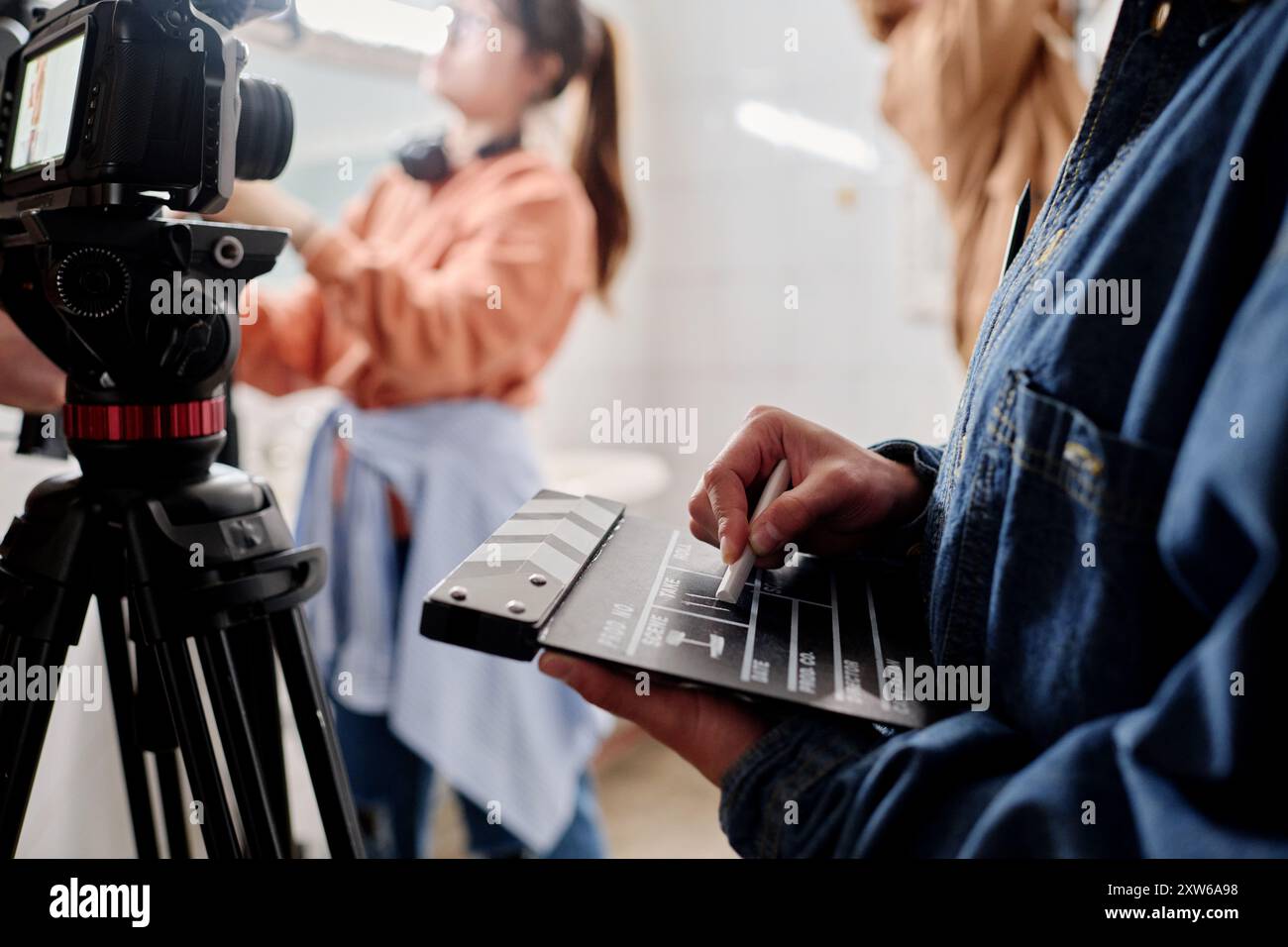 Close-up of hands holding clapperboard while filming with professional ...