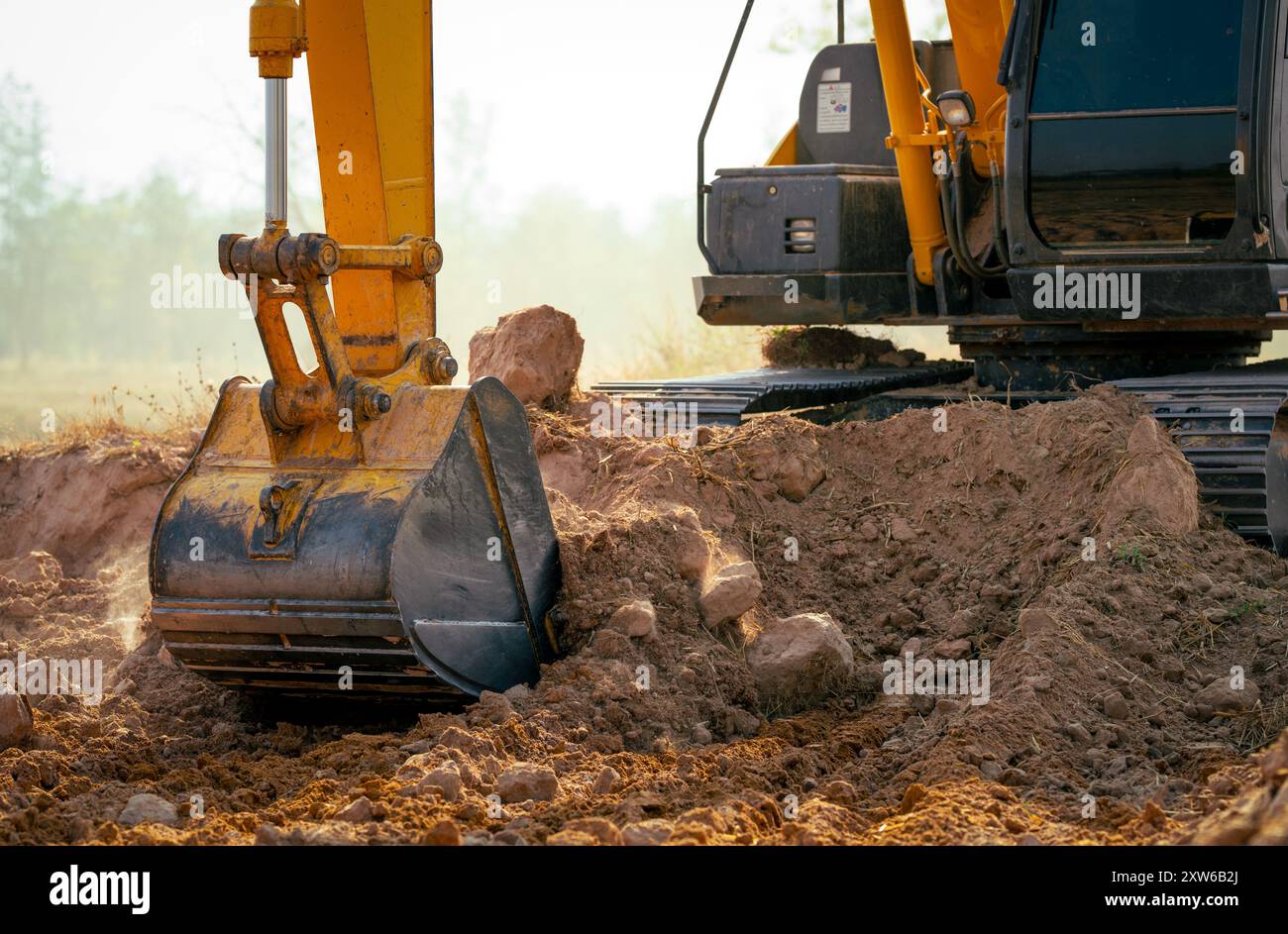 Closeup bucket of backhoe digging the soil at construction site ...
