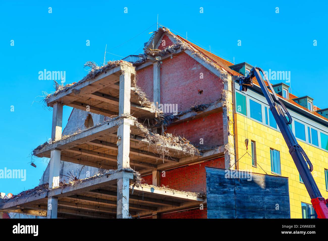Building is being demolished in the city. Crane operates on a building ...