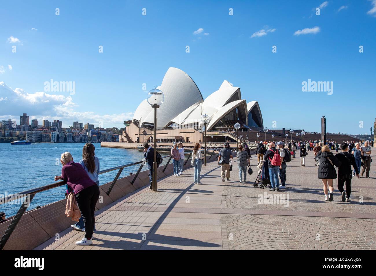 Tourists visit the Sydney Opera House on Sydney harbour, blue sky ...