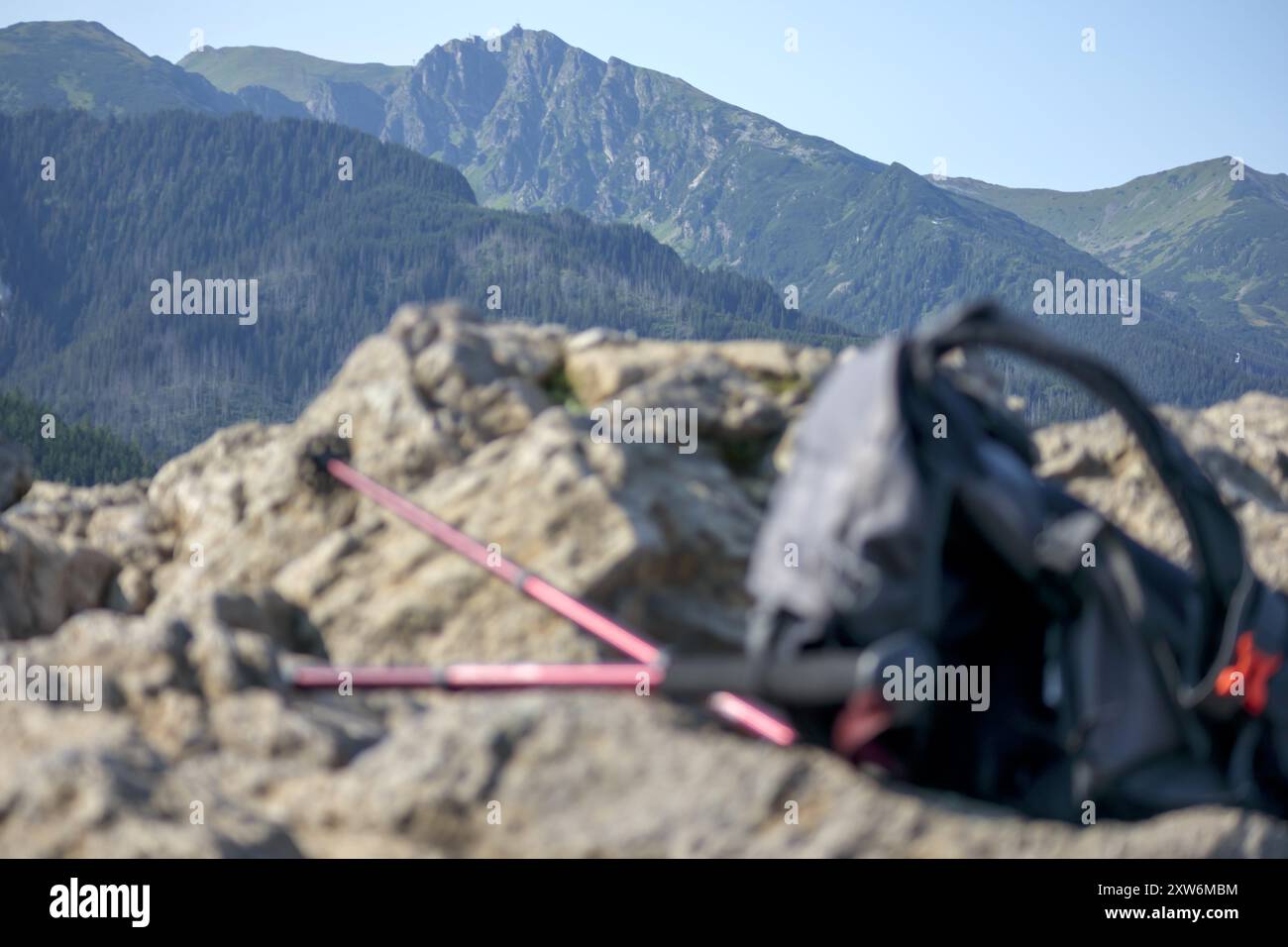 Hiking bag with tourist poles on mountain background Stock Photo - Alamy